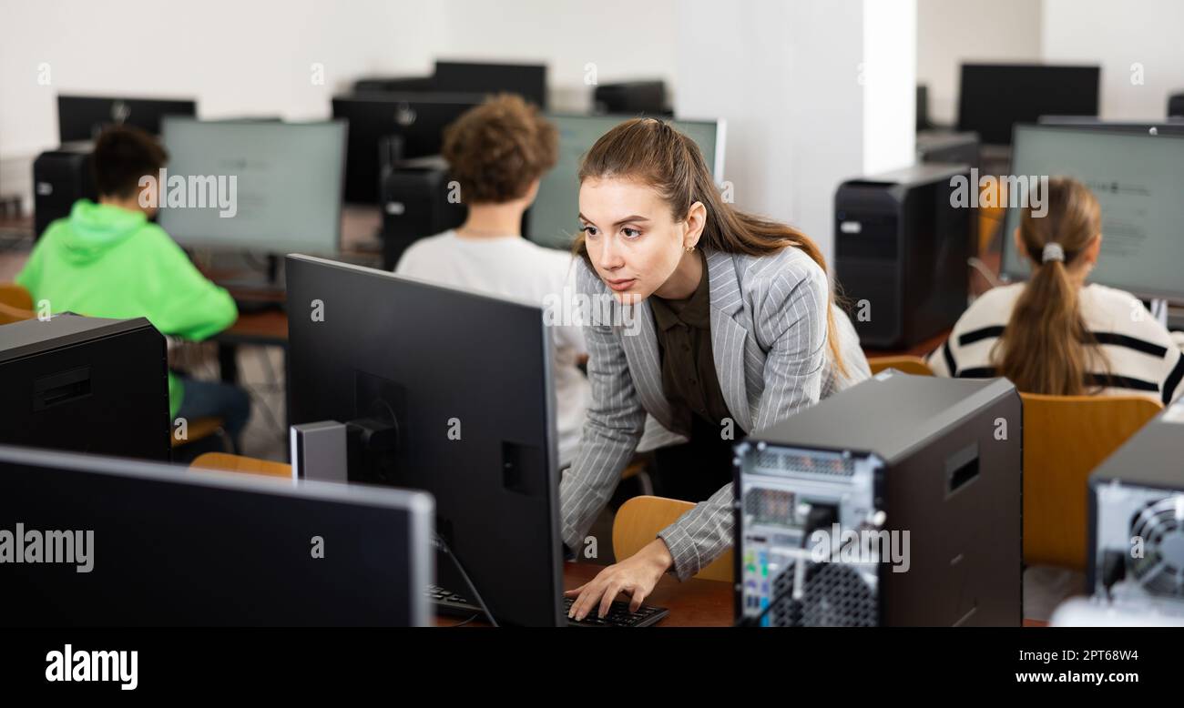 Female teacher working on computer in class Stock Photo - Alamy