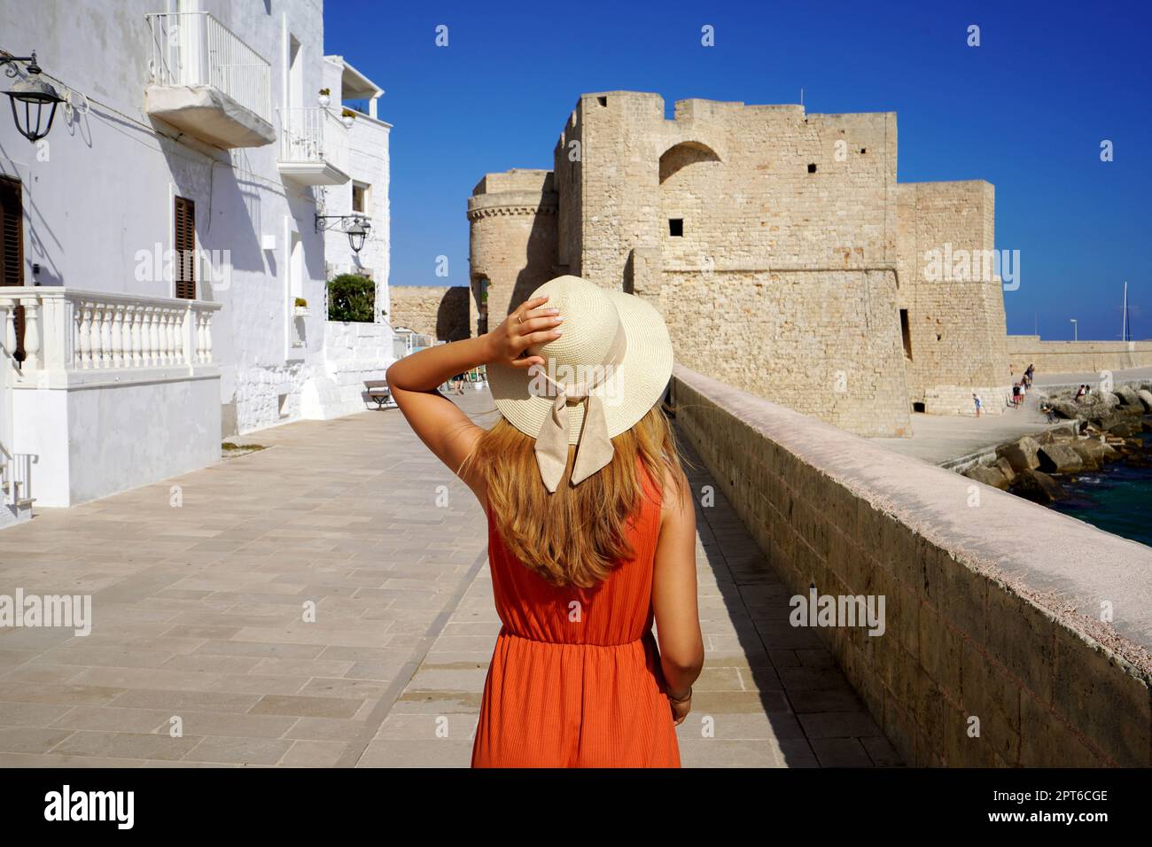 Beautiful young woman walking towards Monopoli castle in Apulia, Italy ...