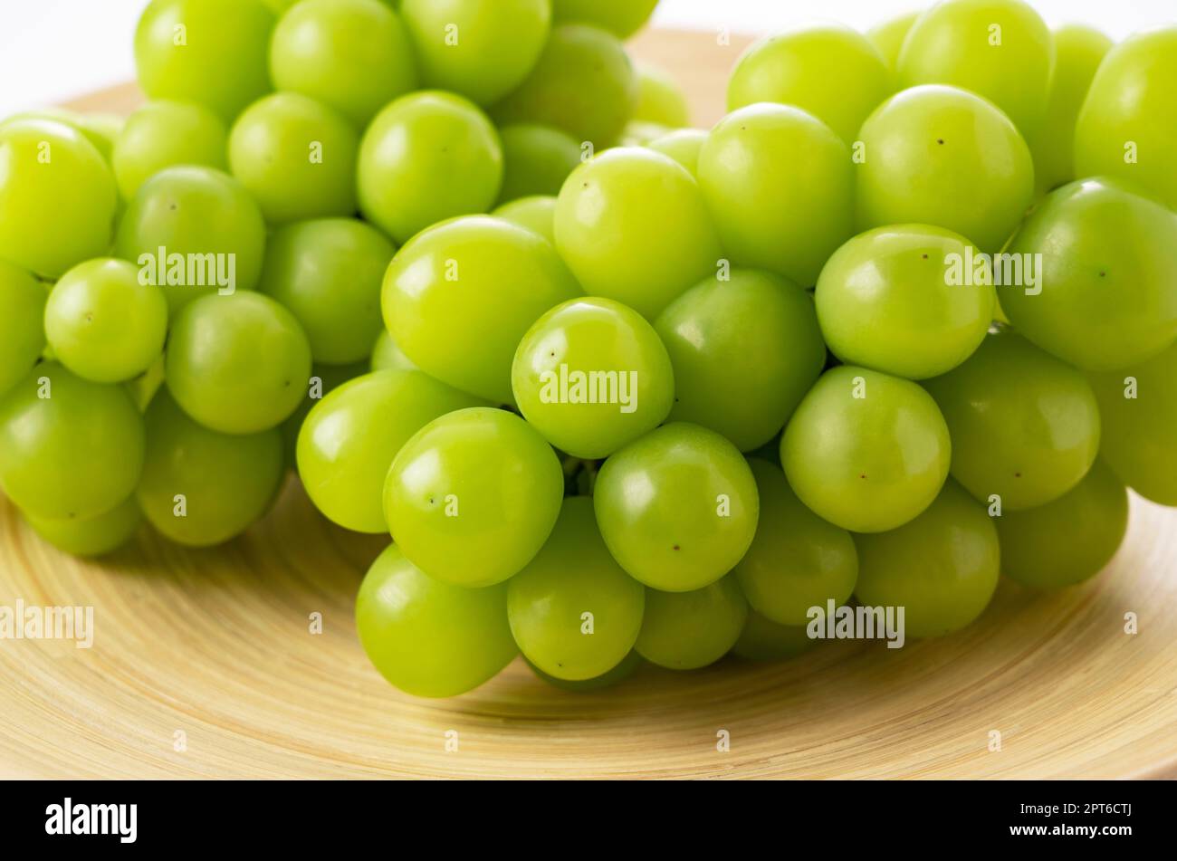 Shine Muscat in a wooden dish on a white background. White grapes ...