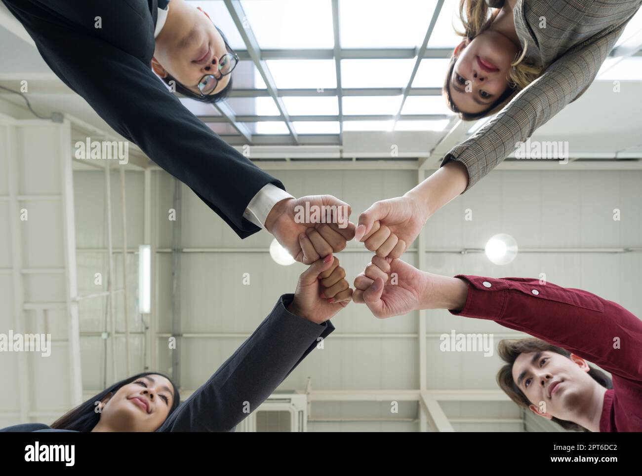 Team building concept. Coworkers standing in circle bumping fist ...