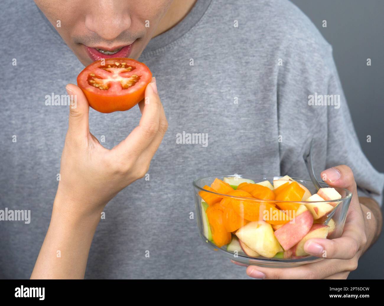 Closeup man mouth, eating a piece of tomato from woman hand while ...
