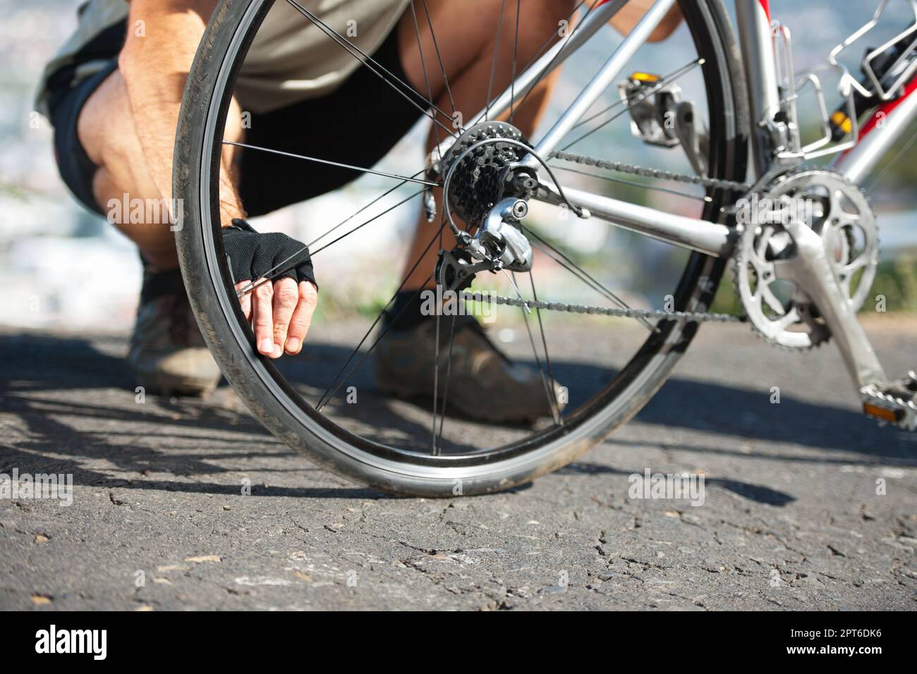 Puncture repair. a cyclist checking the wheel of his bike Stock Photo ...