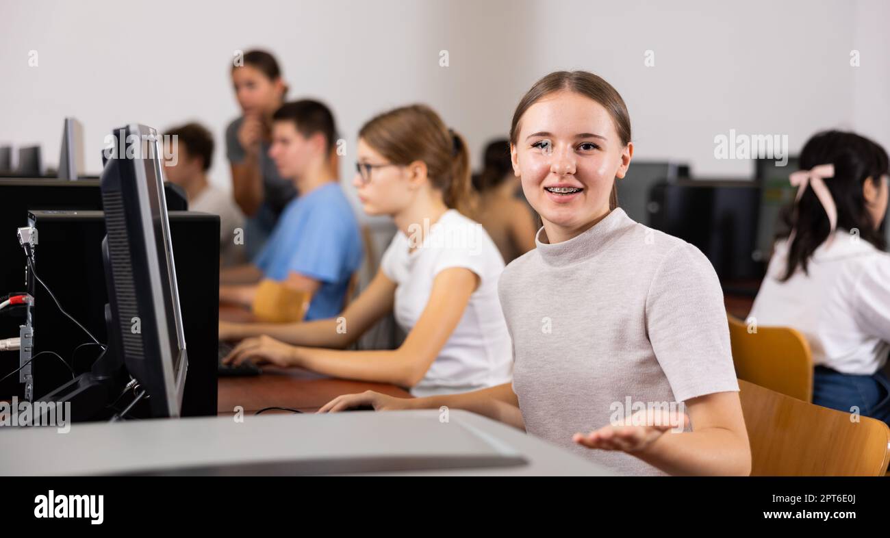 Excited female teenager learning computer science while she is using a ...