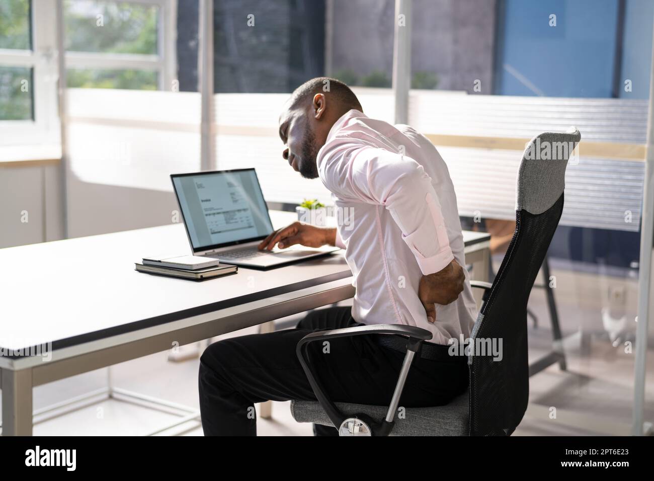 Back Pain Injury From Bad Posture Sitting In Office Stock Photo - Alamy