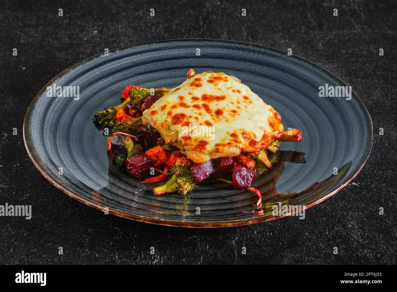 Cod fillet baked with cheese topping served with fried beet, carrot and ...