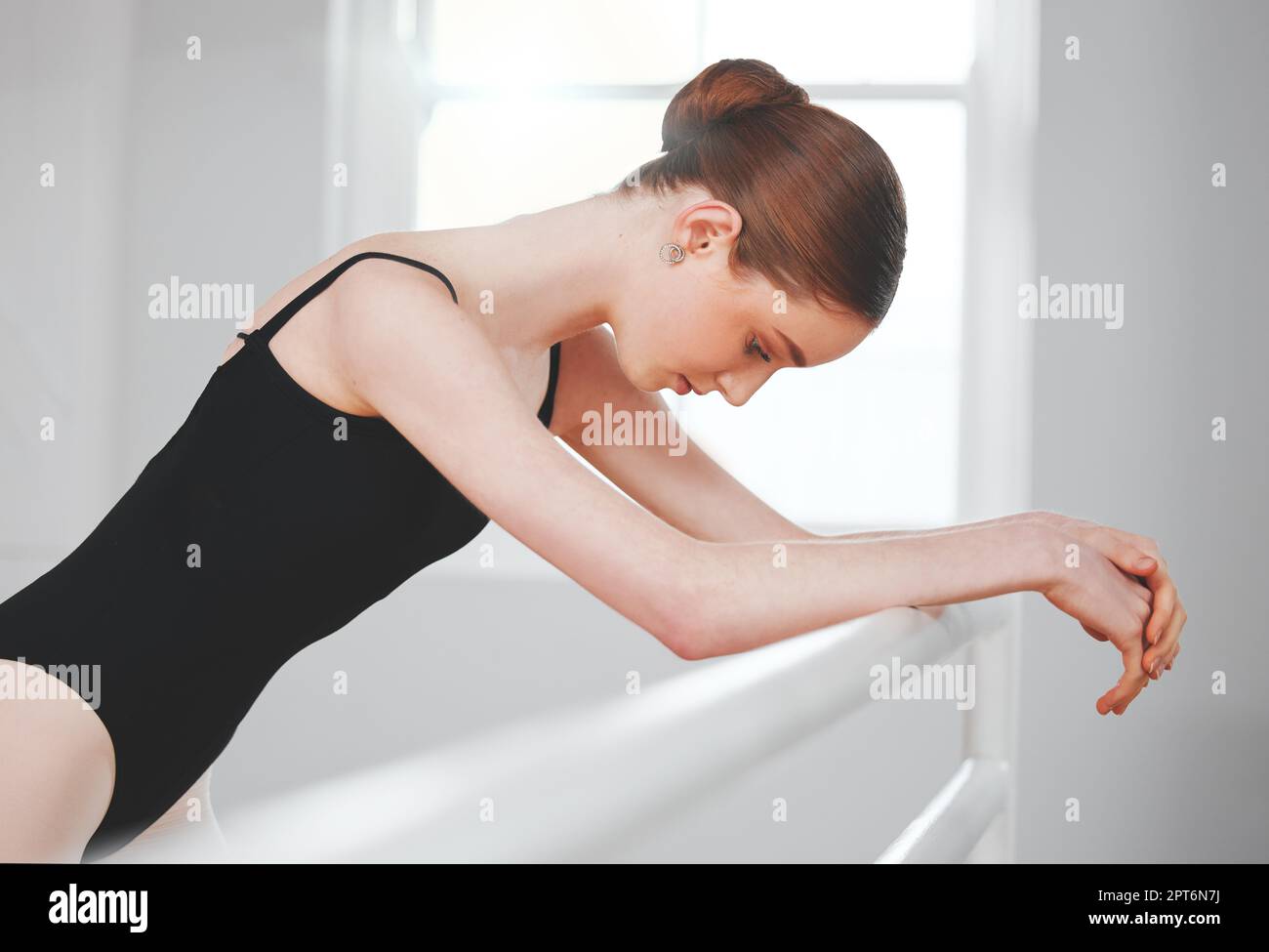 I hope I get this right. a young ballet dancer leaning against a barre ...