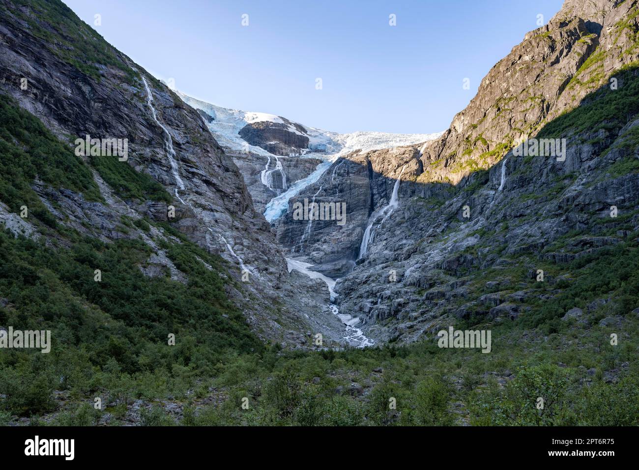 Waterfalls at the glacier tongue Kjenndalsbreen, glacier and mountain ...