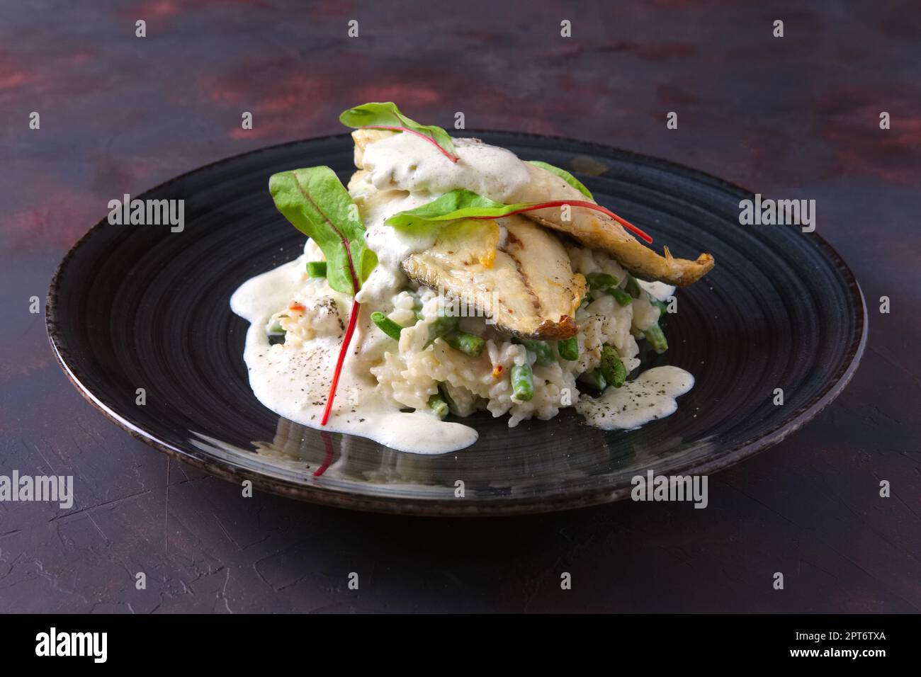 Fried fillet of white fish with rice and green beans decorated with ...