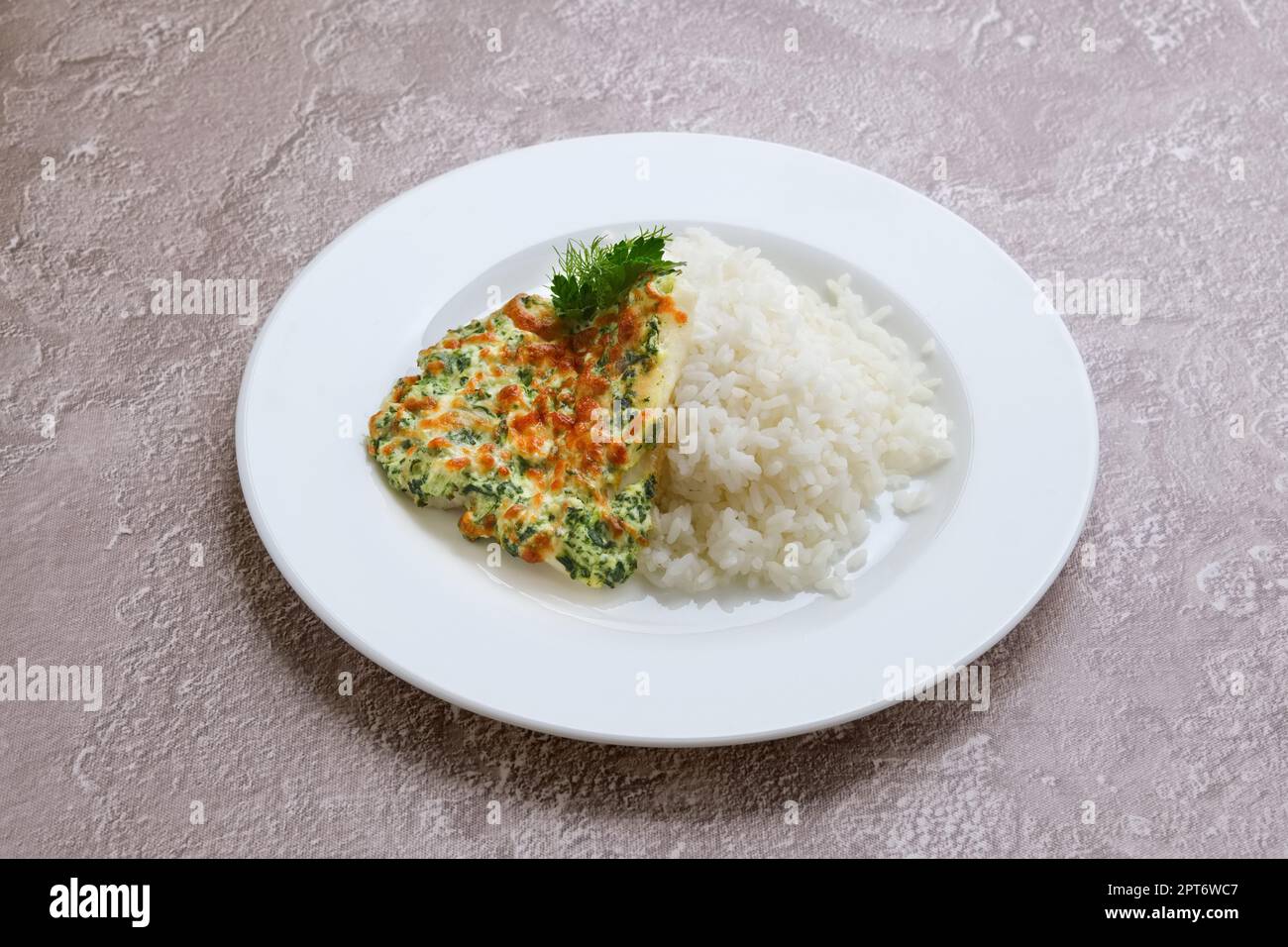 Fried hake fillet with spinach, cheese and rice Stock Photo - Alamy