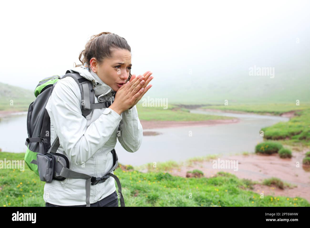 Stressed hiker getting cold walking in the mountain a foggy day Stock ...