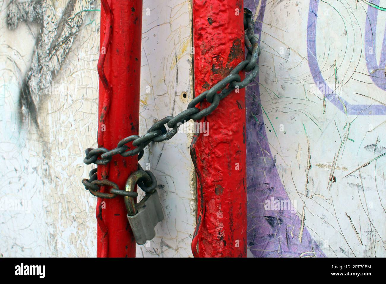 An old padlock on a rusty chain wrapped around red pipes Stock Photo ...
