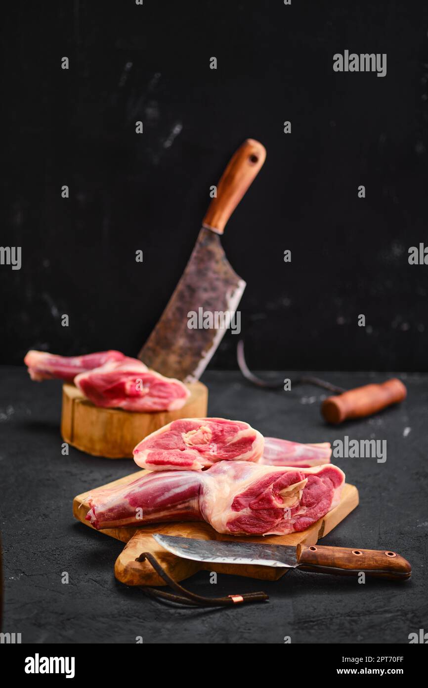 Fresh raw lamb ram shank in the process of cutting (focus on foreground ...