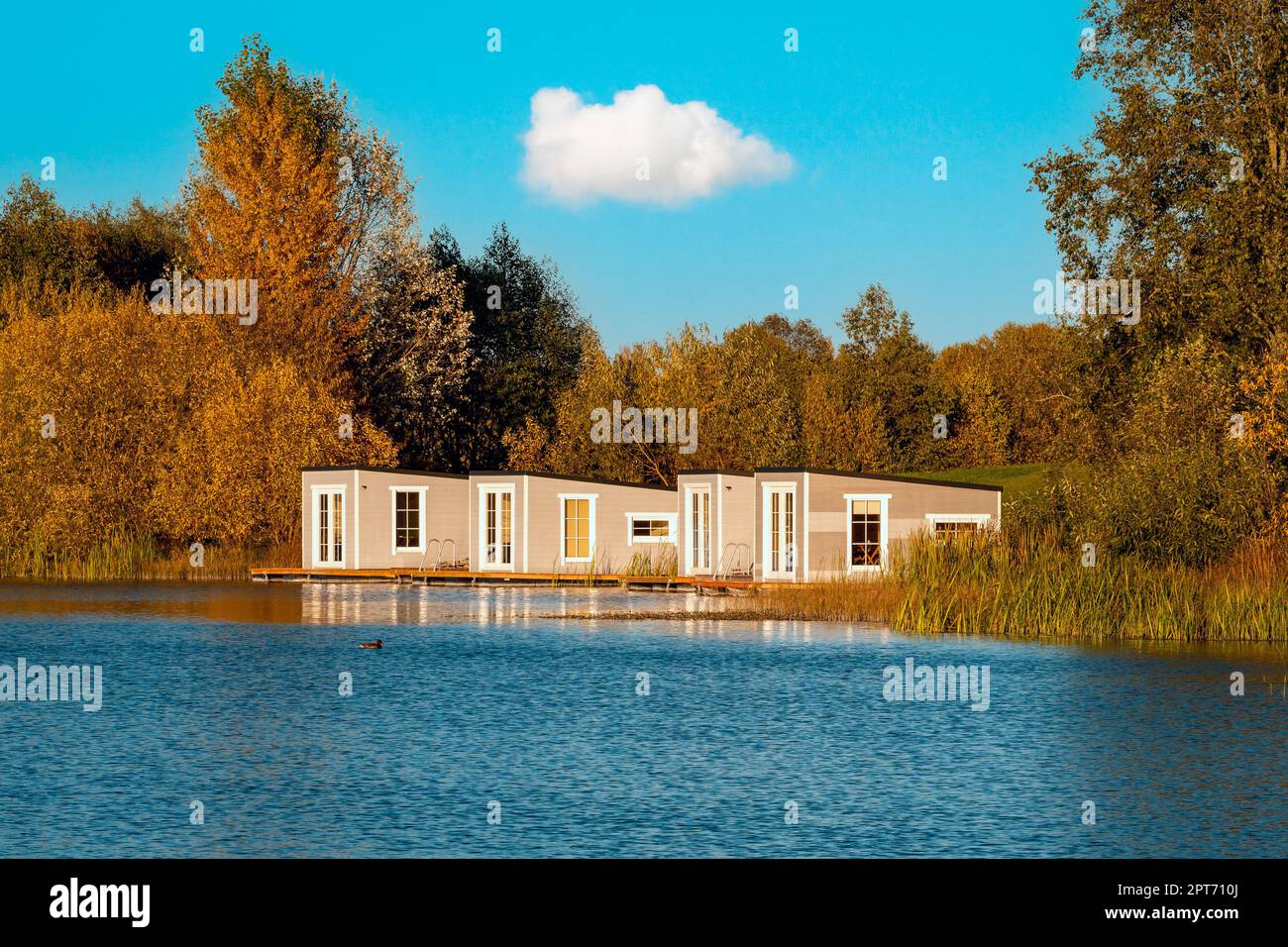 Beautiful autumn landscape with floating grey cabins on the lake and ...