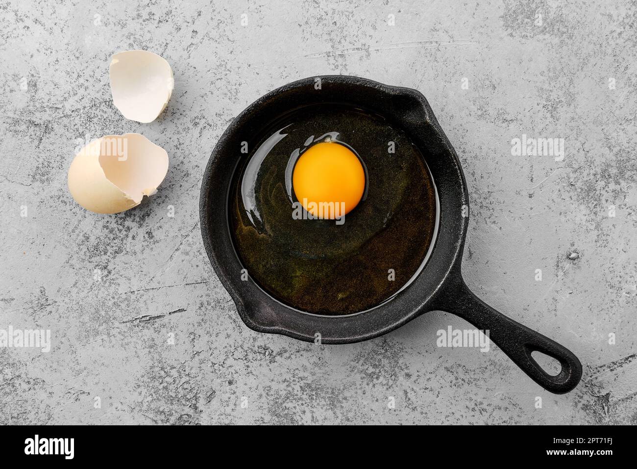 Raw uncooked egg in small cast iron skillet Stock Photo - Alamy