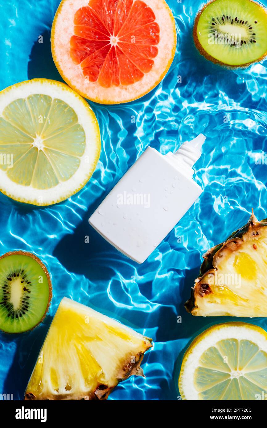 Vertical beauty sunscreen cream vial tube bottle near fruit citrus ...