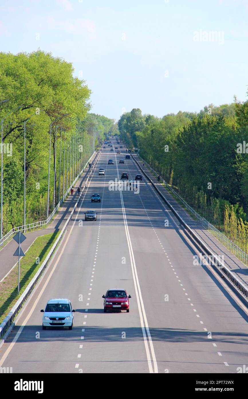 Panorama of motorway with cars and green trees on sides of road. High ...