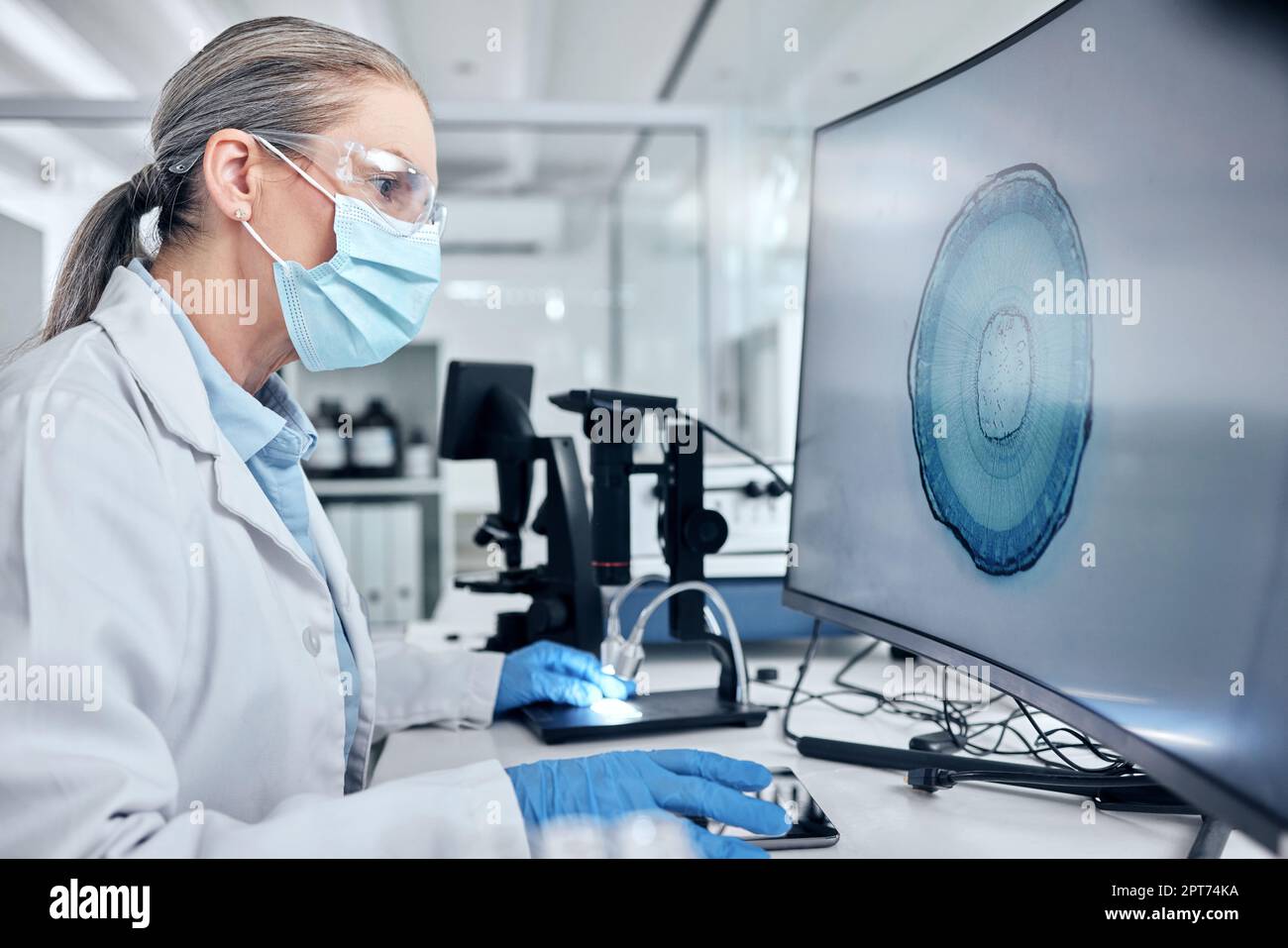 Scientist with computer screen, digital microscope and ppe analysis of ...
