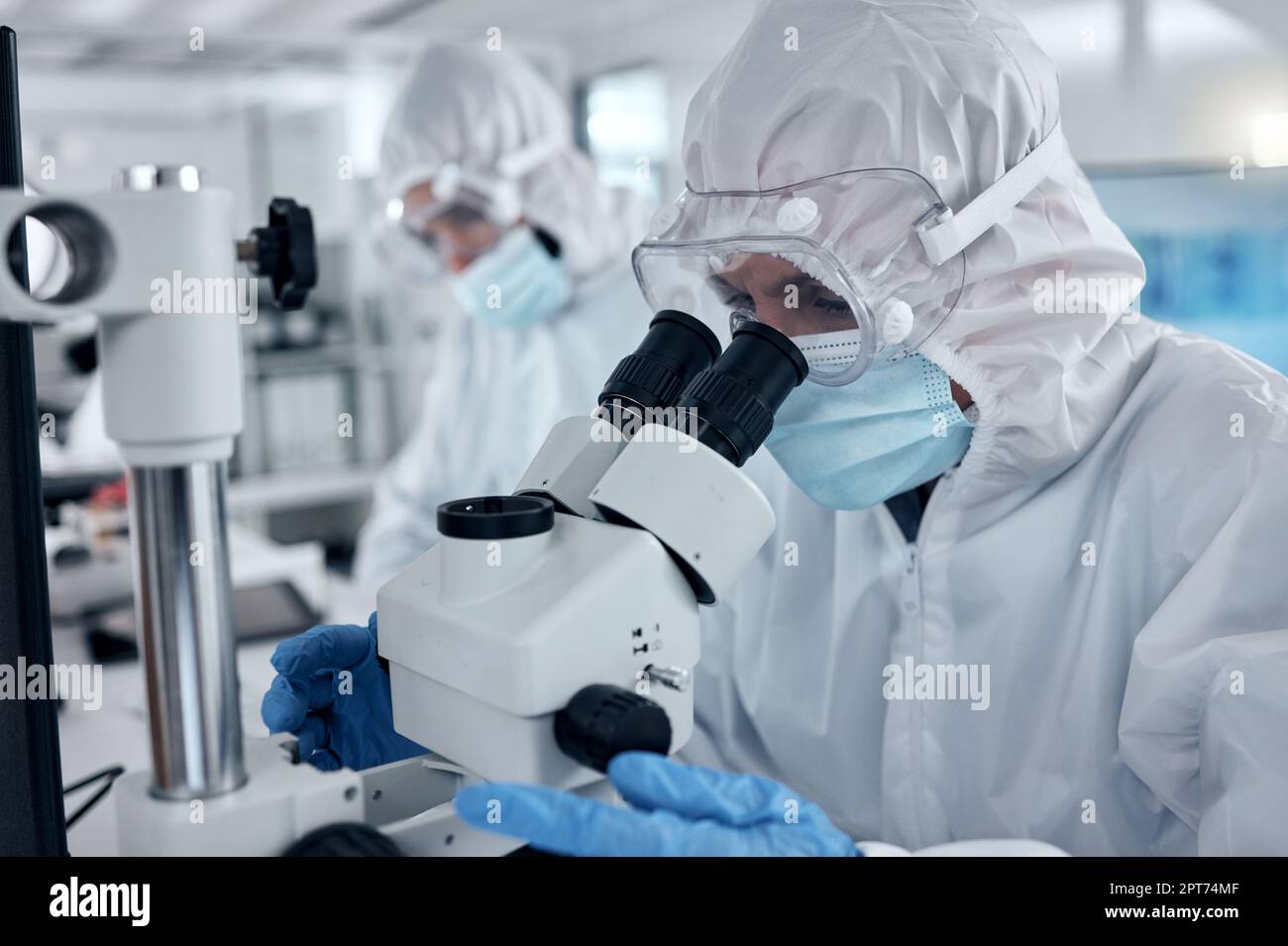 PPE, covid and DNA scientist with microscope research for science ...