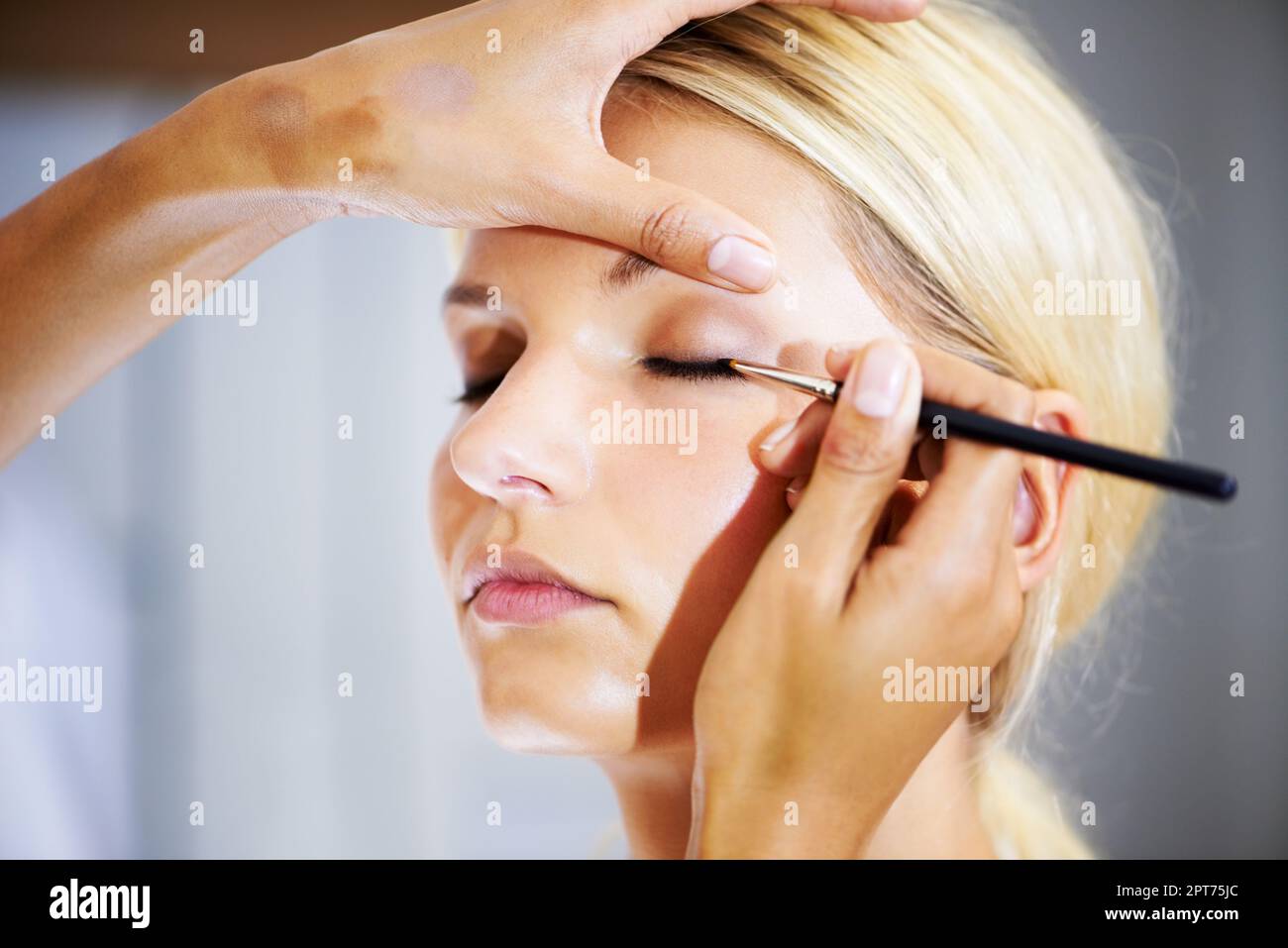 Creating a versatile make-up look. Pretty young woman having her makeup ...
