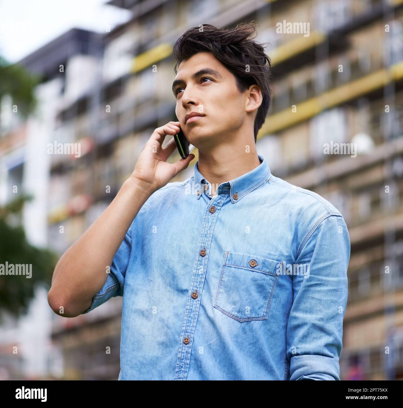 Waiting on an answer. A handsome young man making a call on his ...