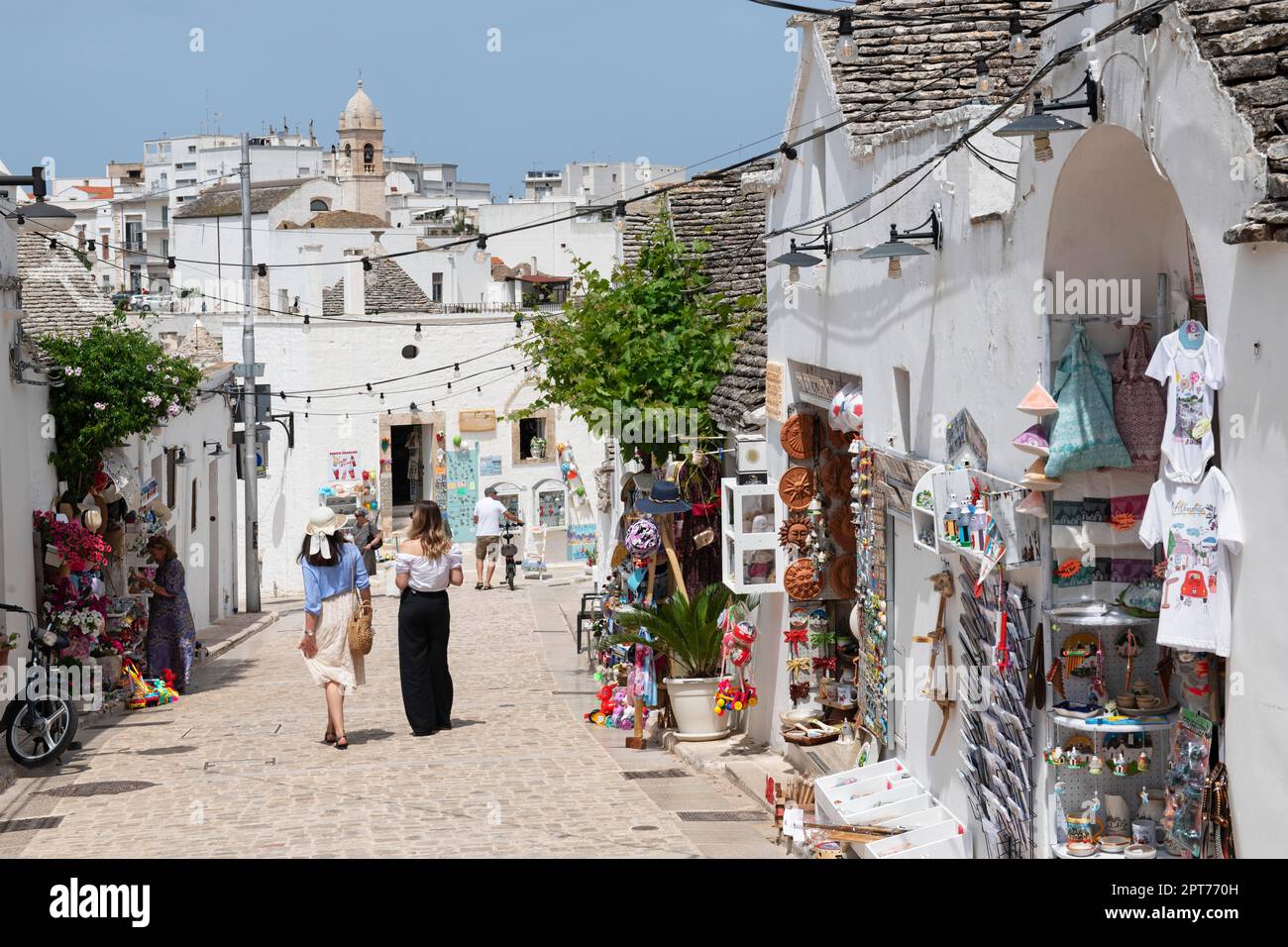 Tourist women between trulli, Alberobello, Valle d'Itria, Apulia, Italy ...