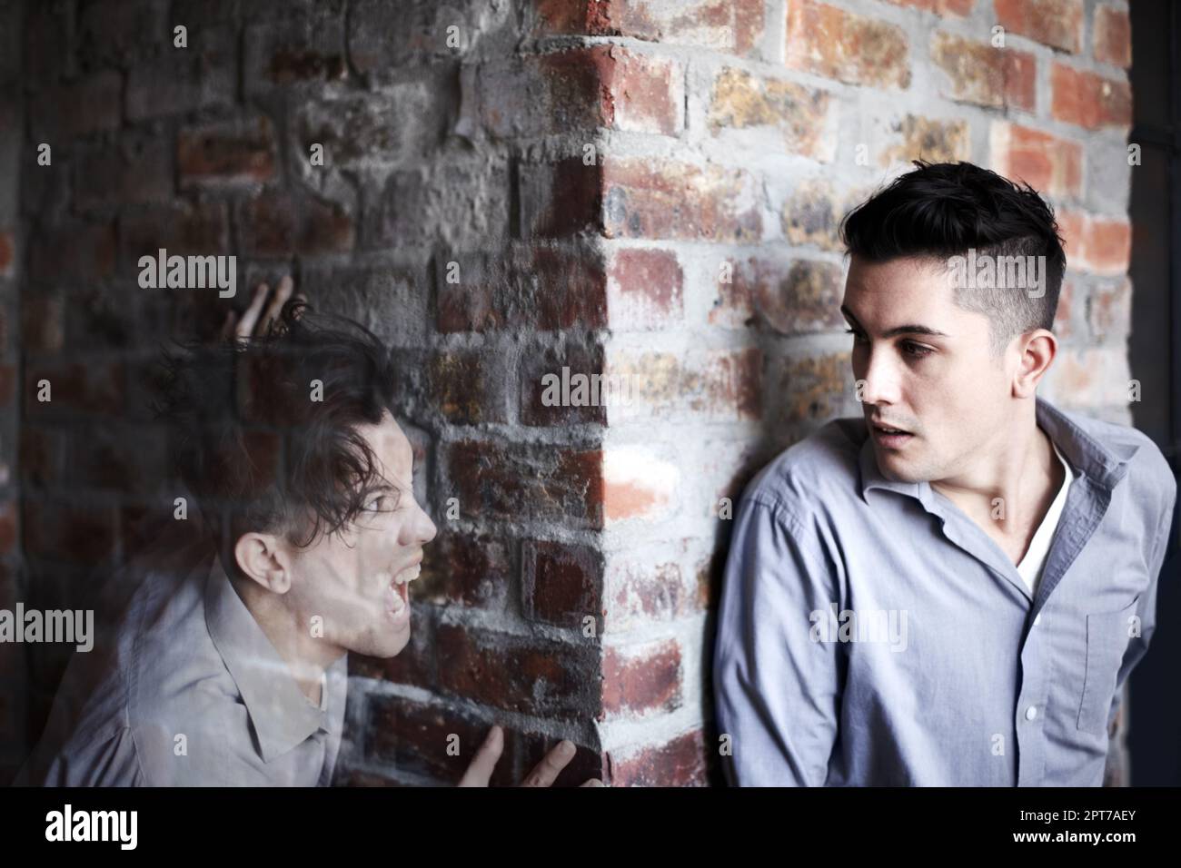 Struggling with his paranoia. a frightened young man hiding from a ...