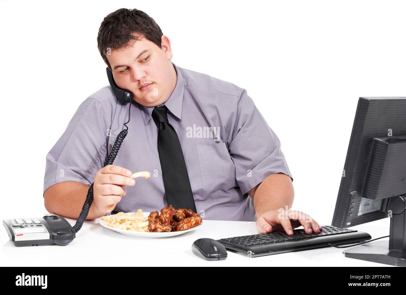 All eating and no exercise. an obese young office work sitting at his ...