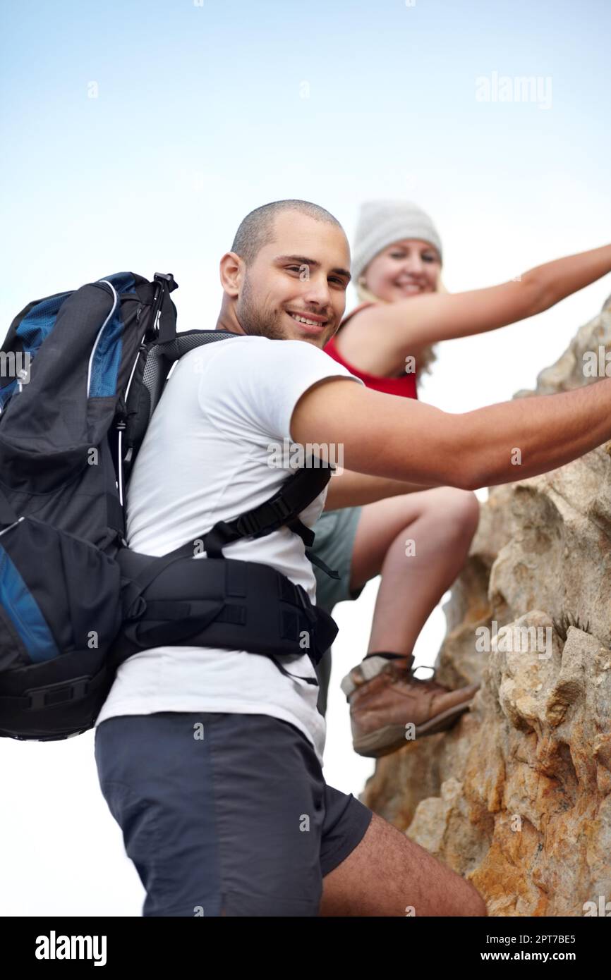 Overcoming obstacles as a couple. Portrait of a young couple climbing a ...