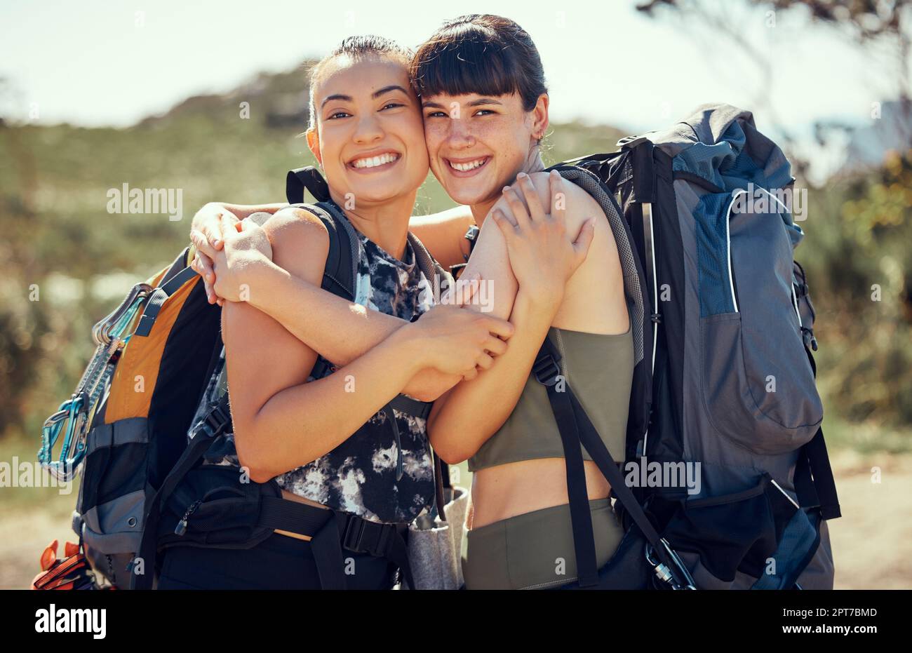 Women mountain hiking, friends hug in nature and outside in summer sun ...