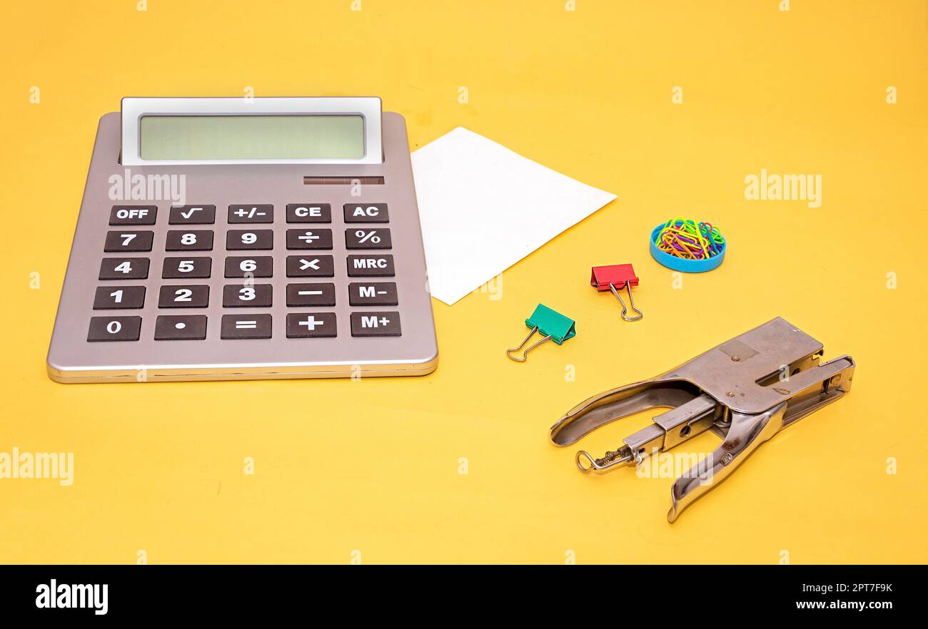 Modern electronic calculator with metal stapler and paperclips office ...