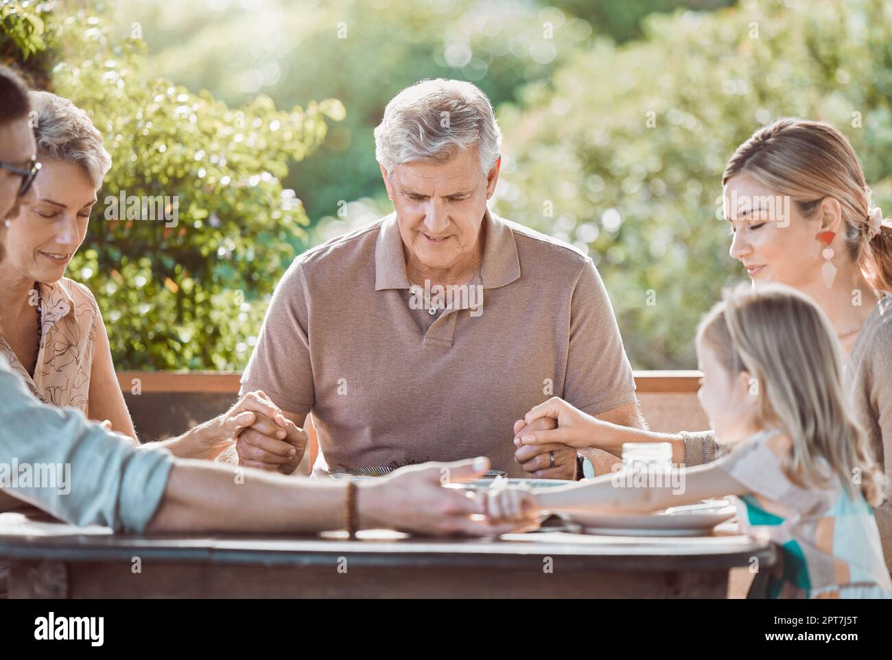 Thanking God for our meal. a family sitting together and praying before ...