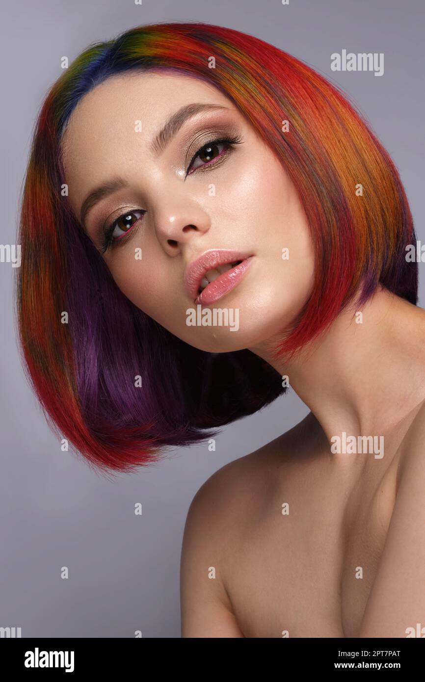 Portrait of beautiful woman with multi-colored hair and creative make ...