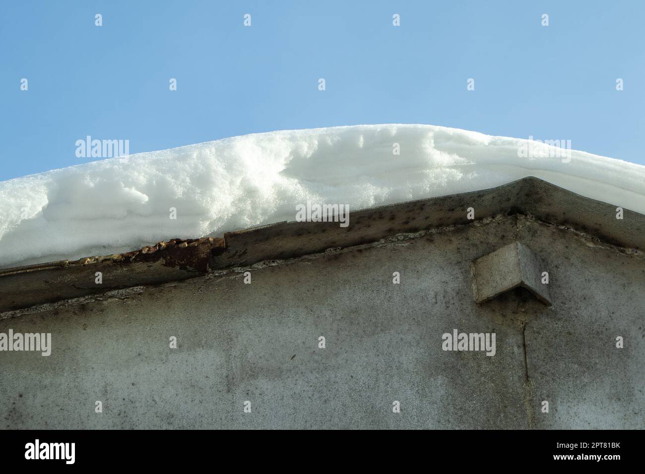 Snow drift on the metal roof of the garage after a snowfall. Close-up ...