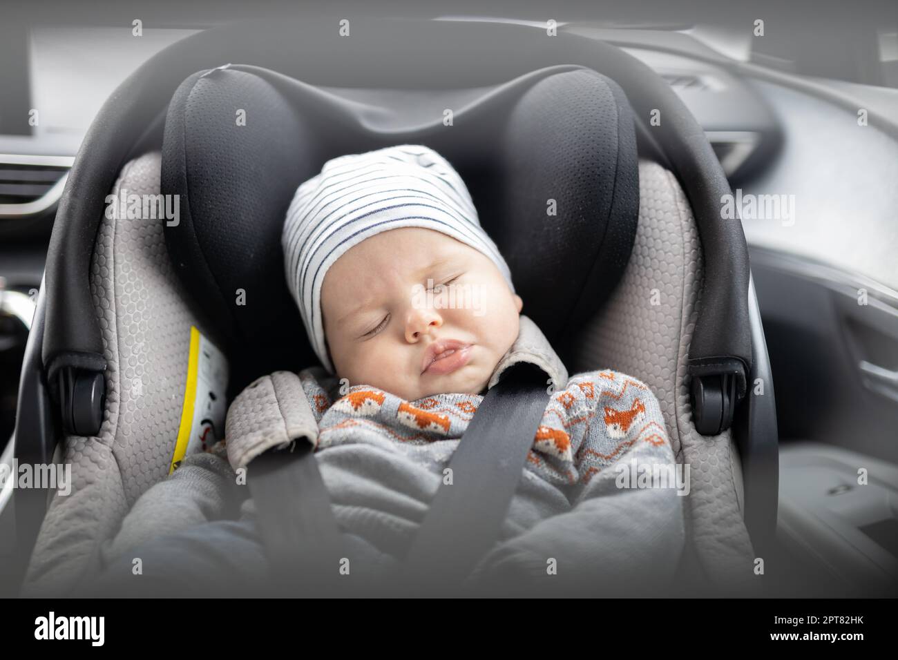 Cute little baby boy sleeping strapped into infant car seat in ...