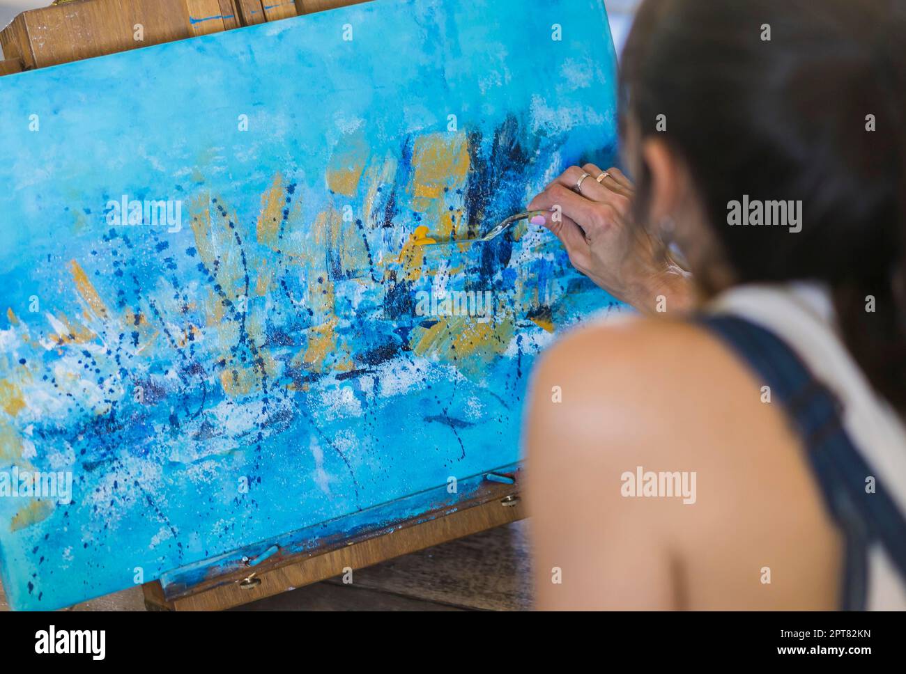 Concentrated woman painting on canvas hi-res stock photography and ...