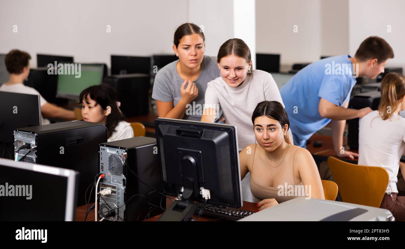 Portrait of young girls using pc and discussing while studying in ...