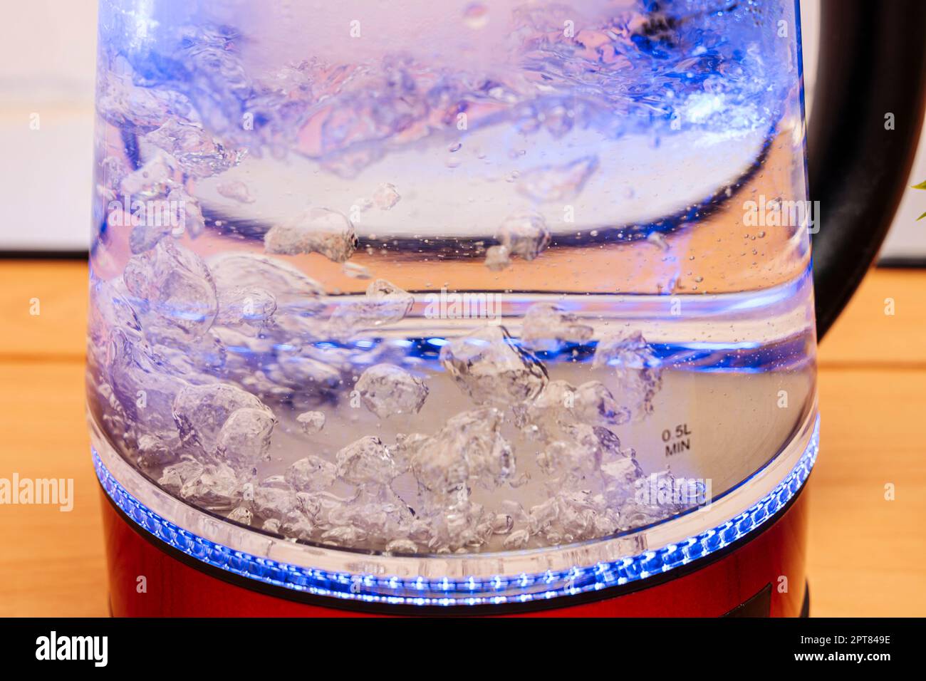 red modern boiling glass electric kettle close-up with bubbling water ...
