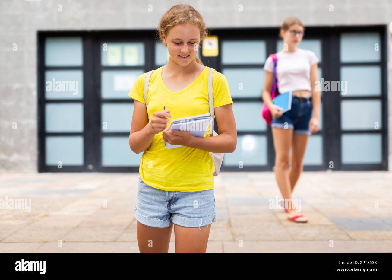 Two young girls going home after school Stock Photo - Alamy