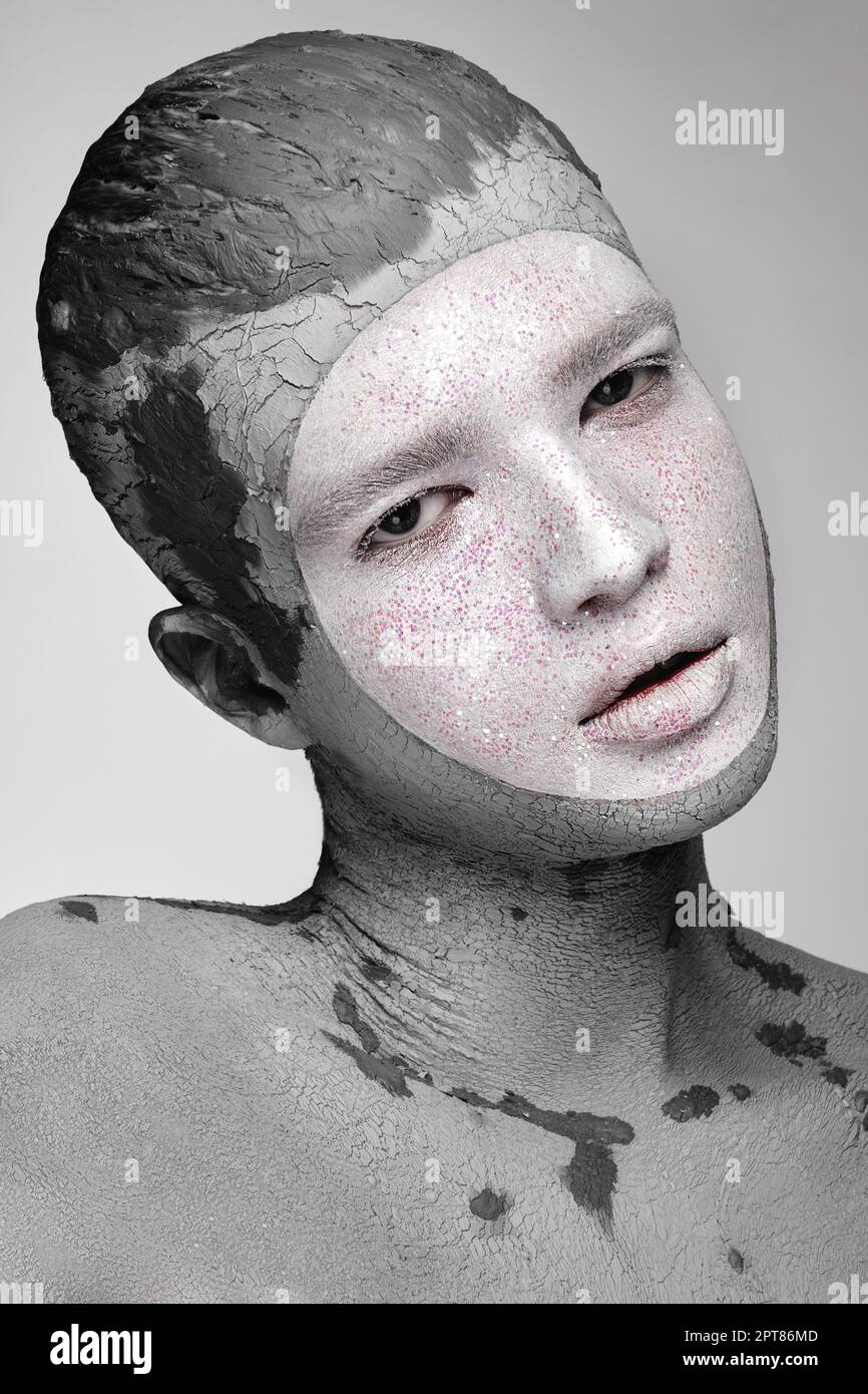 Young man with art creative make-up with mud on his face. Cosmetic mask ...