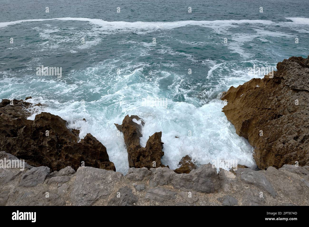 Waves breaking on the shore on a pebble road. water foam, wild waters ...
