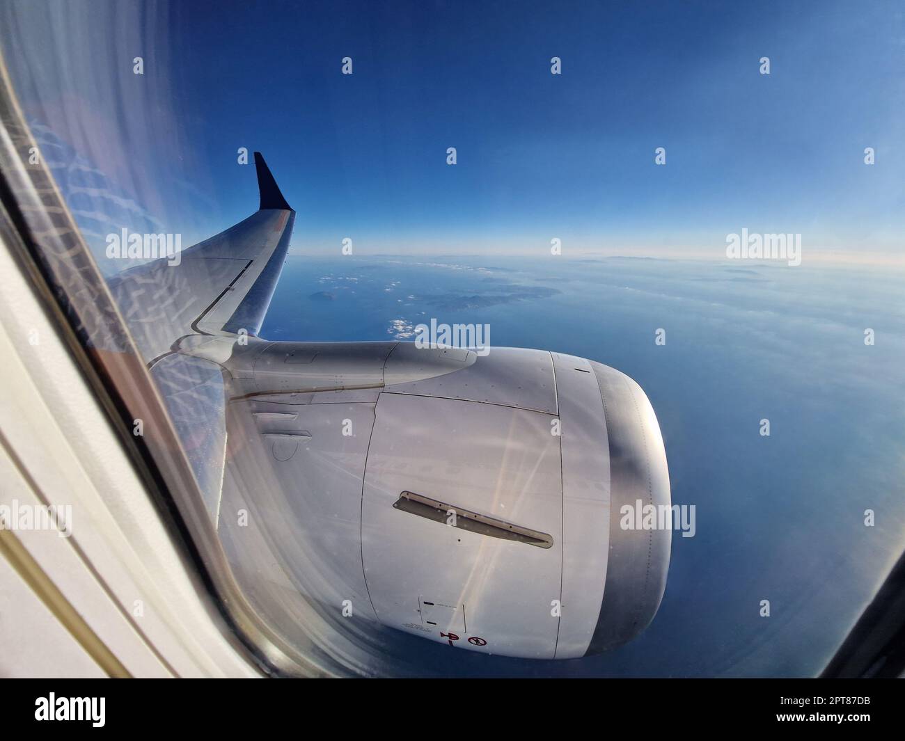 A view of blue sky through airplane window during flight. View from ...