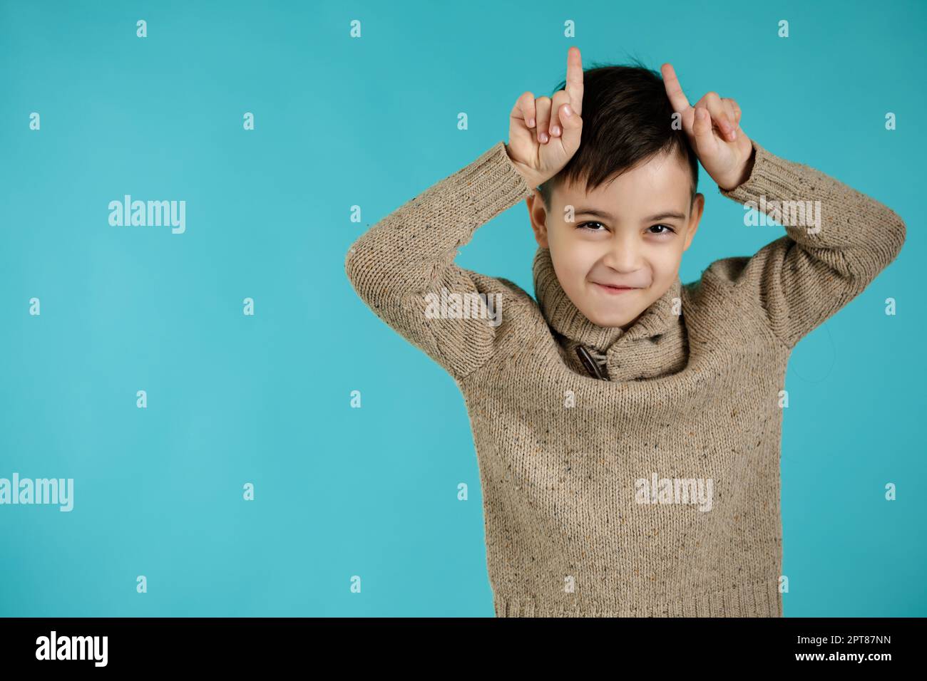 happy funny little child boy doing funny gesture with finger over head ...