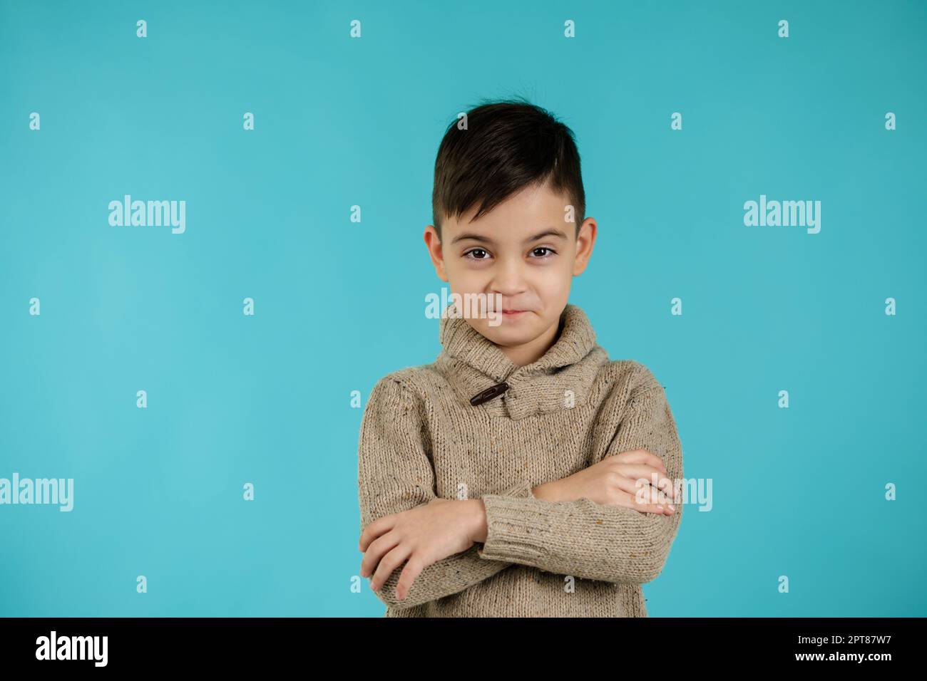 Cute little child boy thinks about something on blue background. Human ...