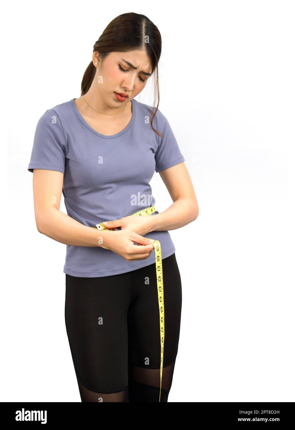 Young asian woman in exercise clothes use a tape measure to measure ...