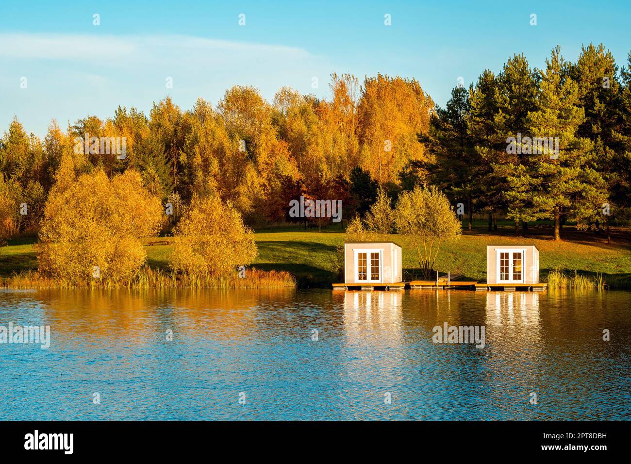 Fall season landscape with floating grey cabins on the lake and ...