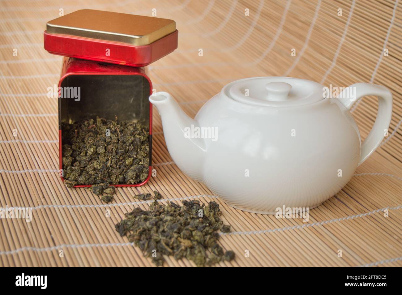 Teapot and a tin of traditional Asian green tea loose Stock Photo - Alamy