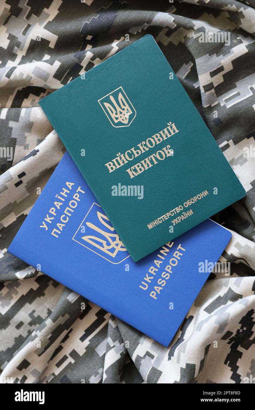 Ukrainian military ID and foreign passport on fabric with texture of ...