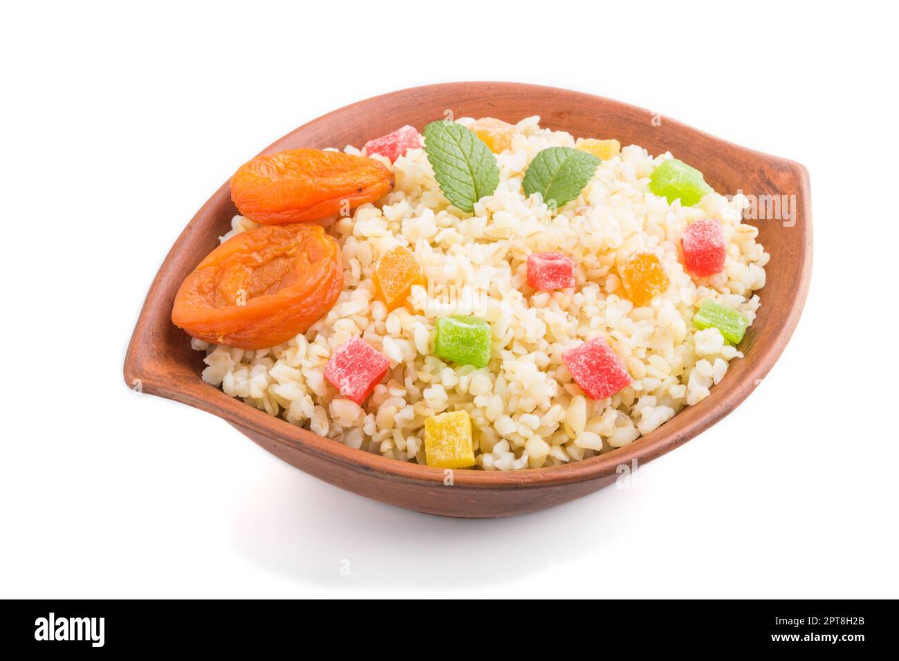 Bulgur porridge with dried apricots and candied fruits in clay bowl ...