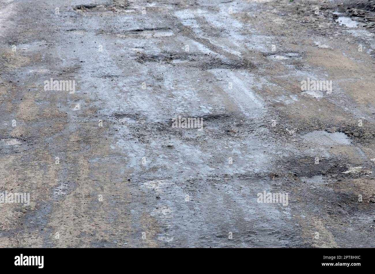Damaged asphalt road with potholes caused by freezing and thawing ...