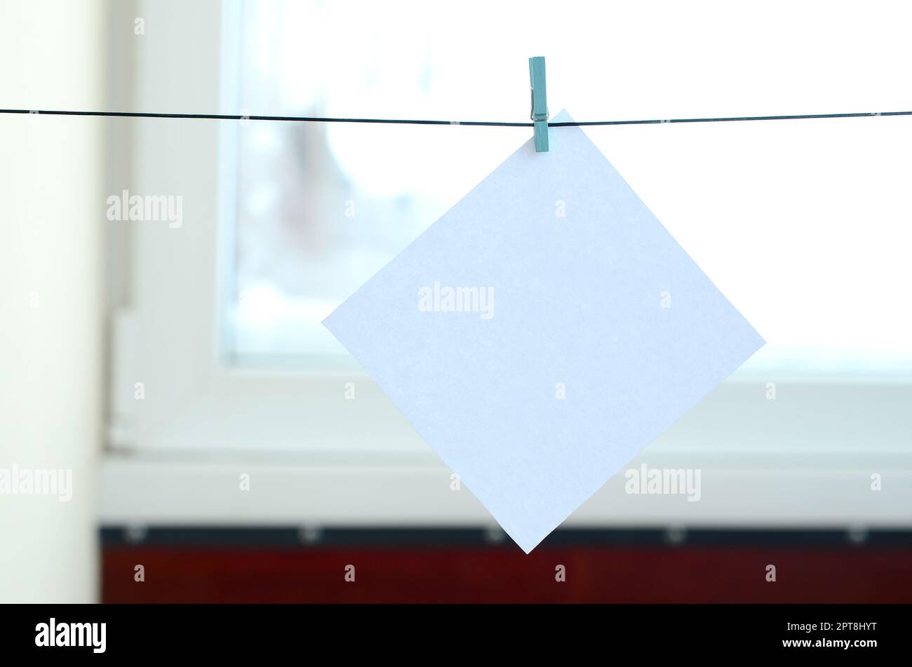 White blank card on rope, window glass background. Creative reminder ...